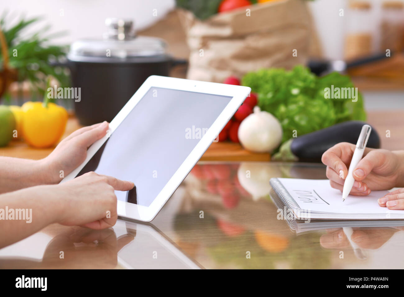 Closeup of human hands cooking in kitchen using touch pad. Women ...