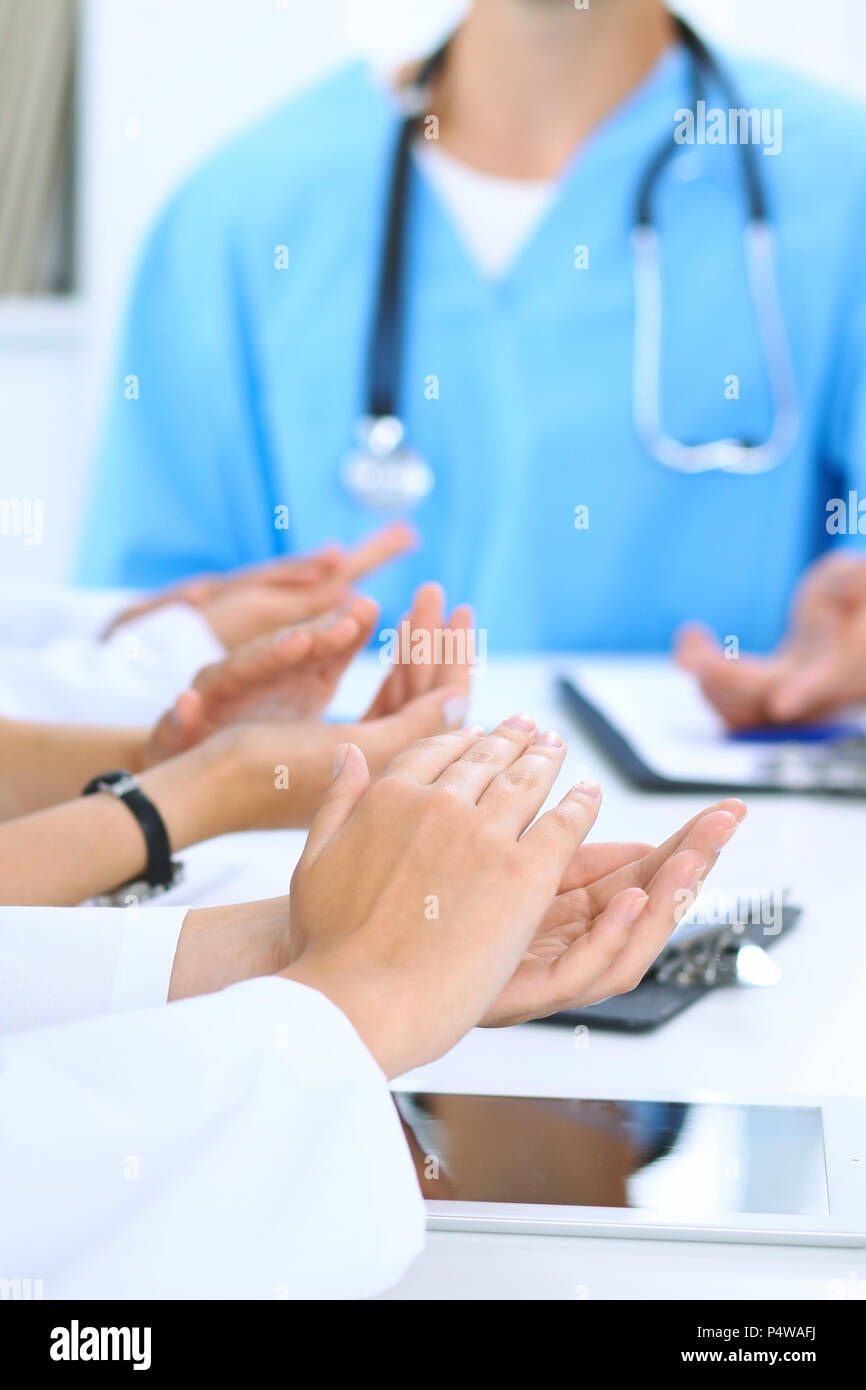 Group of doctors applauding at medical meeting. Close up of physician ...