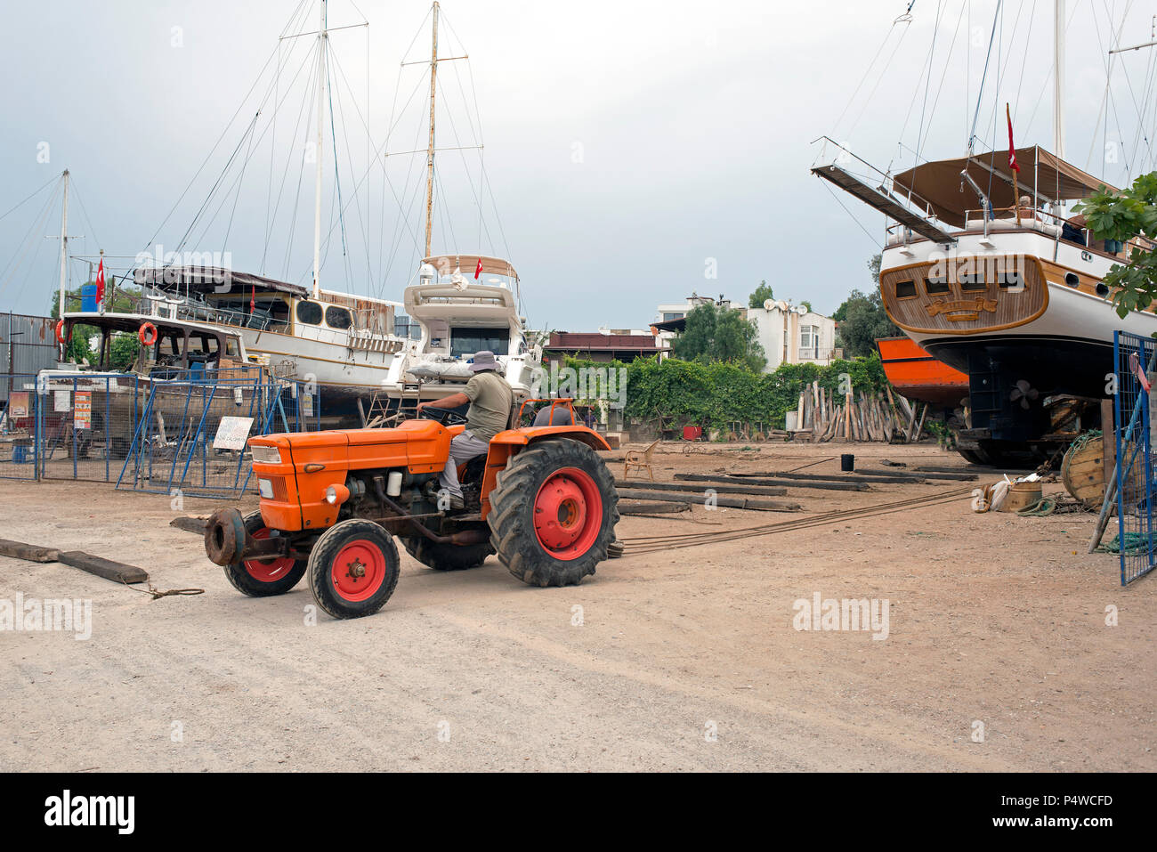 A tractor pulling a boat to the sea from shipyard in Bodrum, Turkey ...