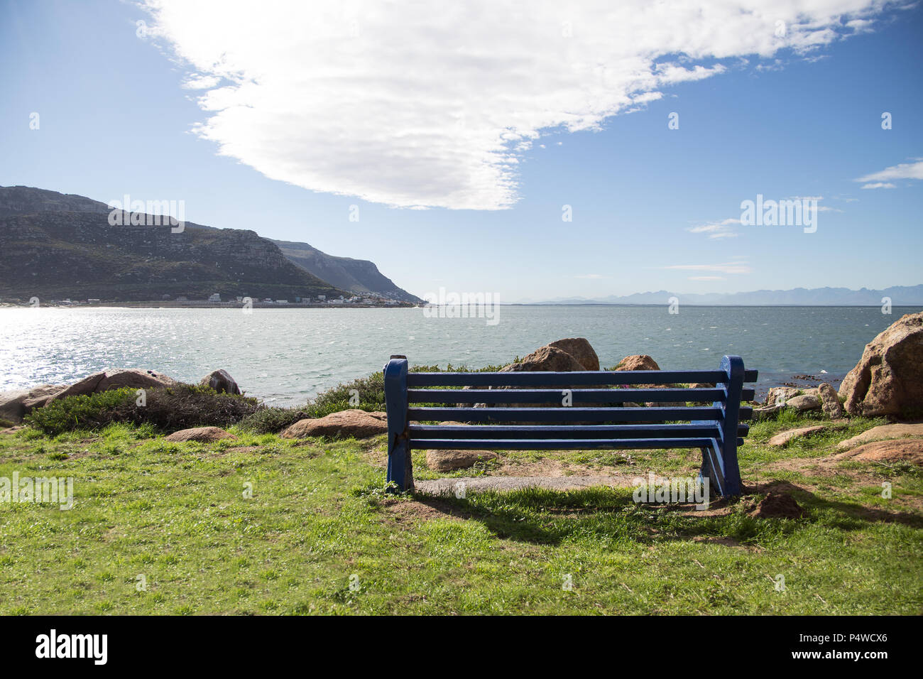 Blue Bench Under the Clouds facing the ocean Stock Photo - Alamy