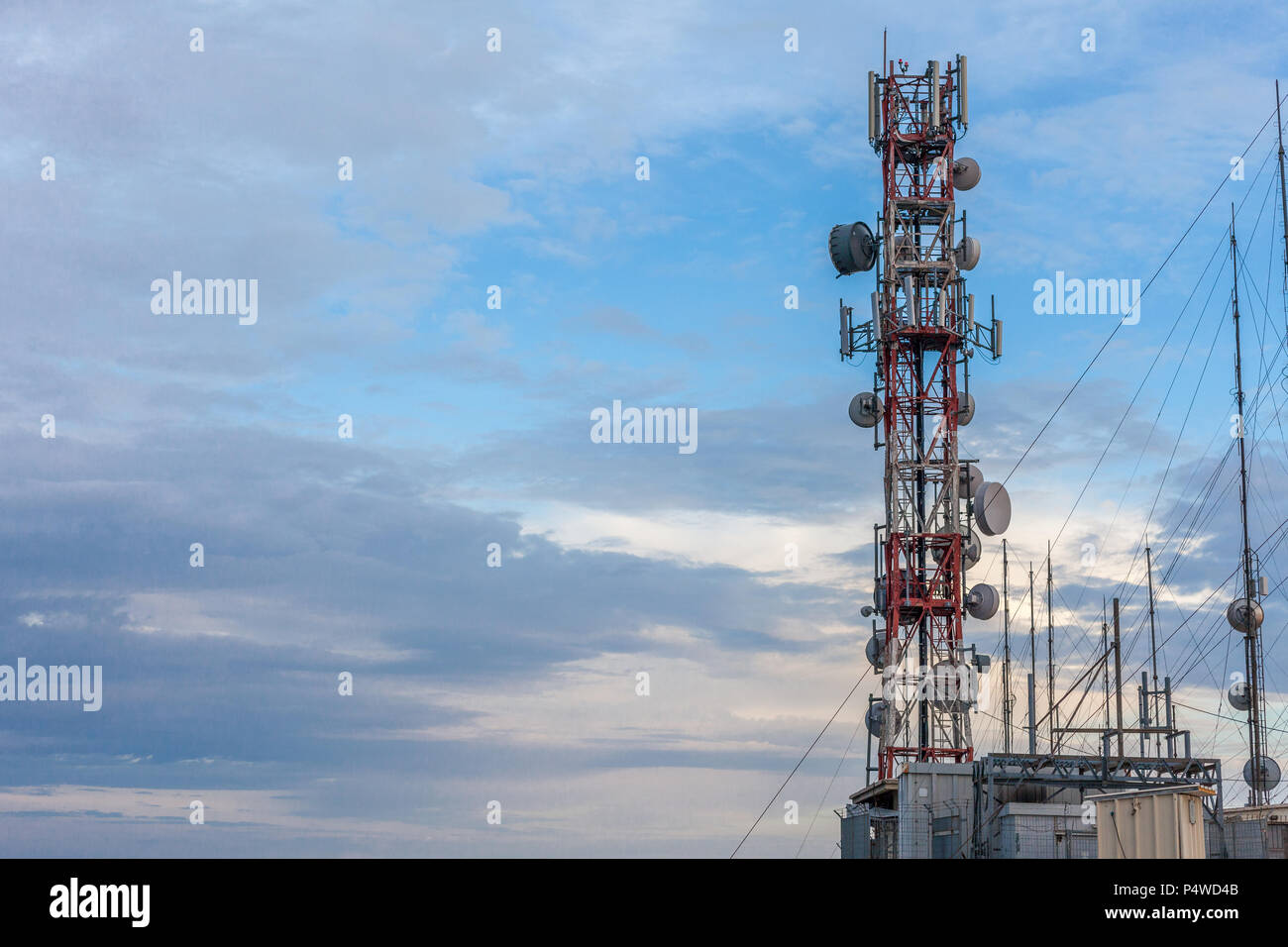 Air broadcast antenna towering high in top of the building. Microwave ...