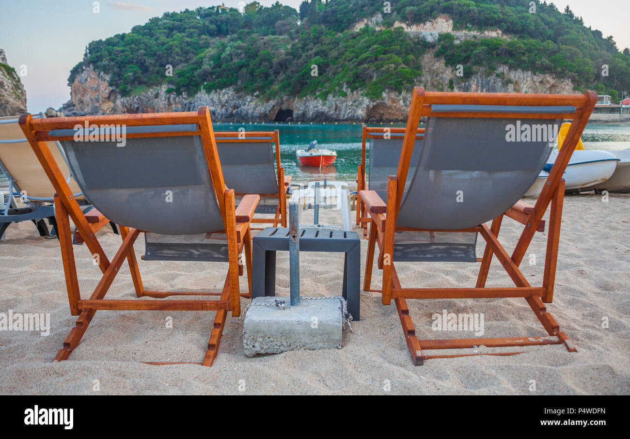 Portable lazy chair set up in the beach. A mountainous rock in the ...