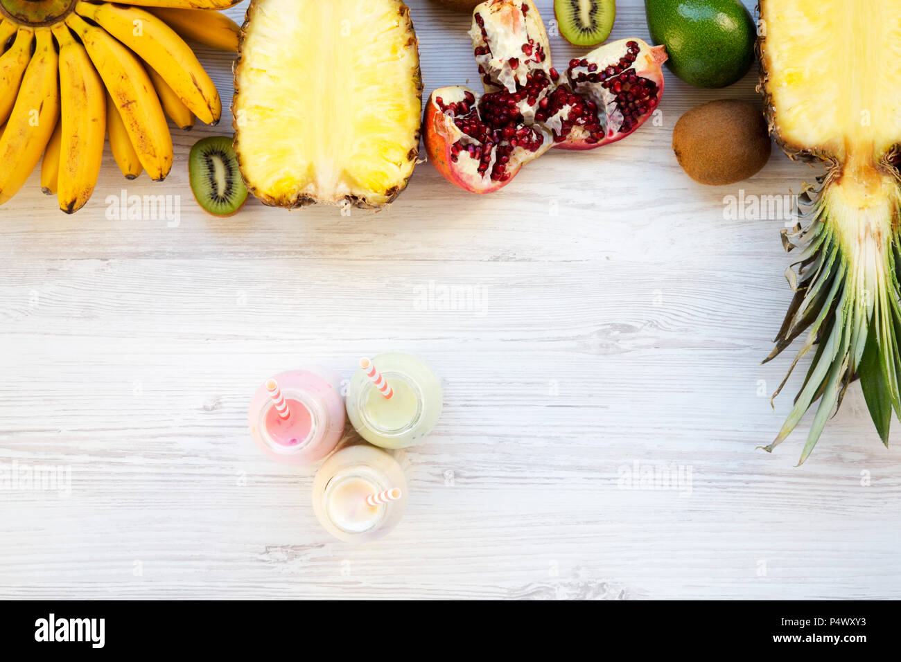 Fruit smoothies of different tastes in glass jars on white wooden ...