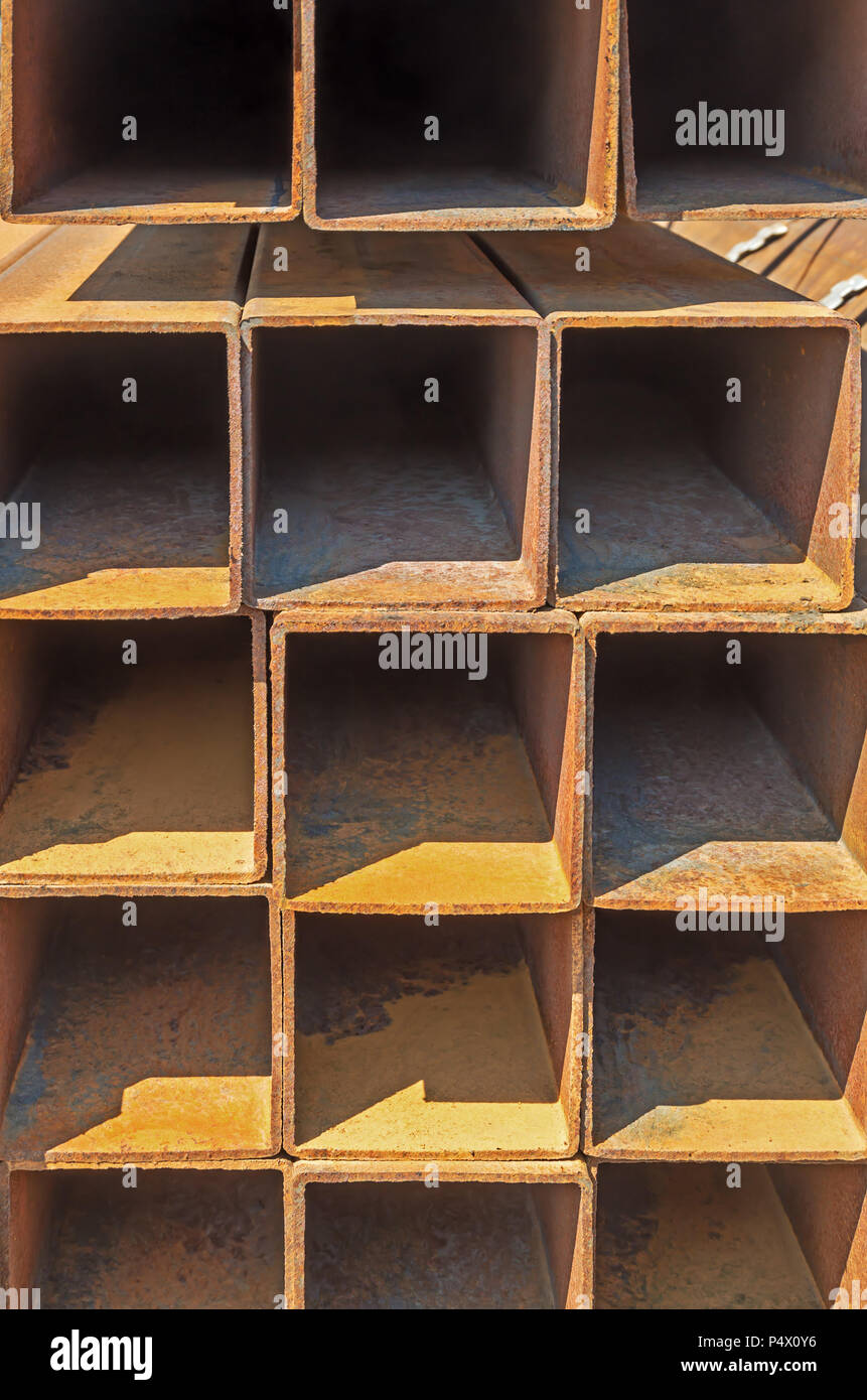 The manufactured by welding square rusty steel pipes piled up warehouse ...
