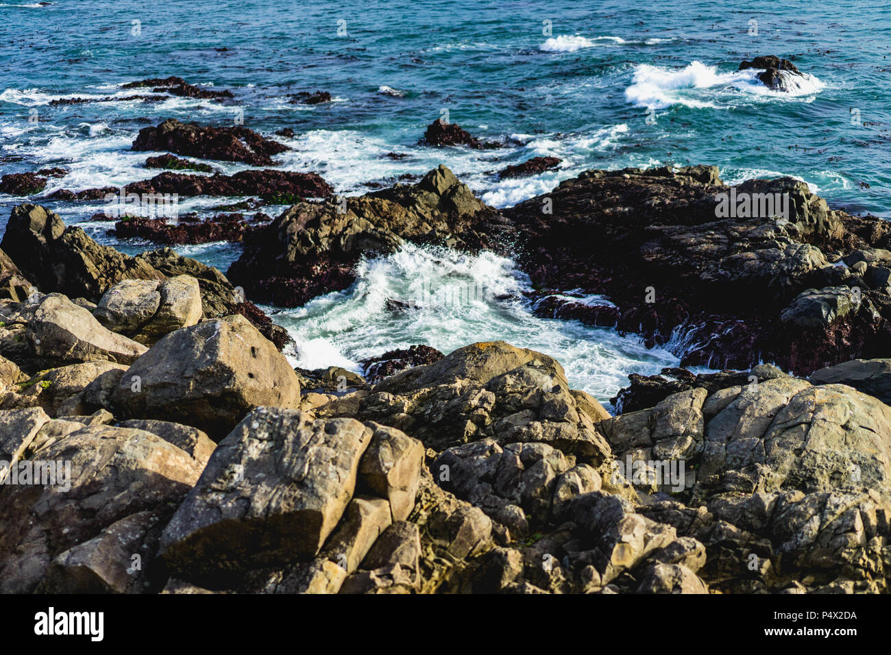 Ocean with big rocks and water crashing into them Stock Photo - Alamy