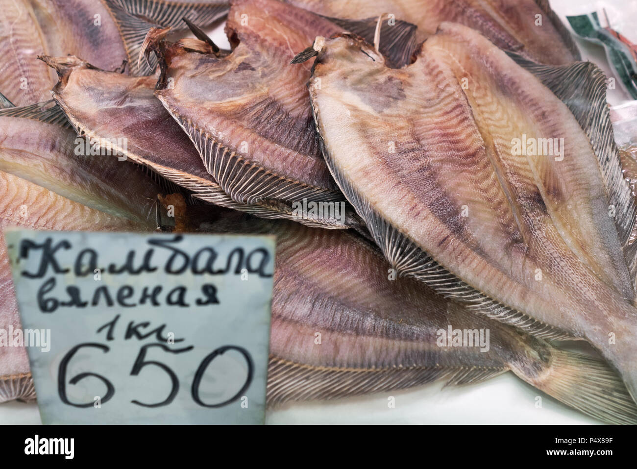 Close-up view of dried salted flatfish with price on counter at fish ...