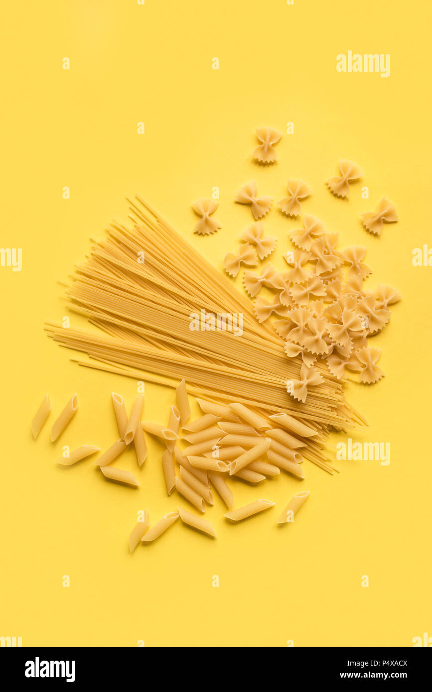 Assorted various uncooked raw pasta on yellow background. Italian pasta ...