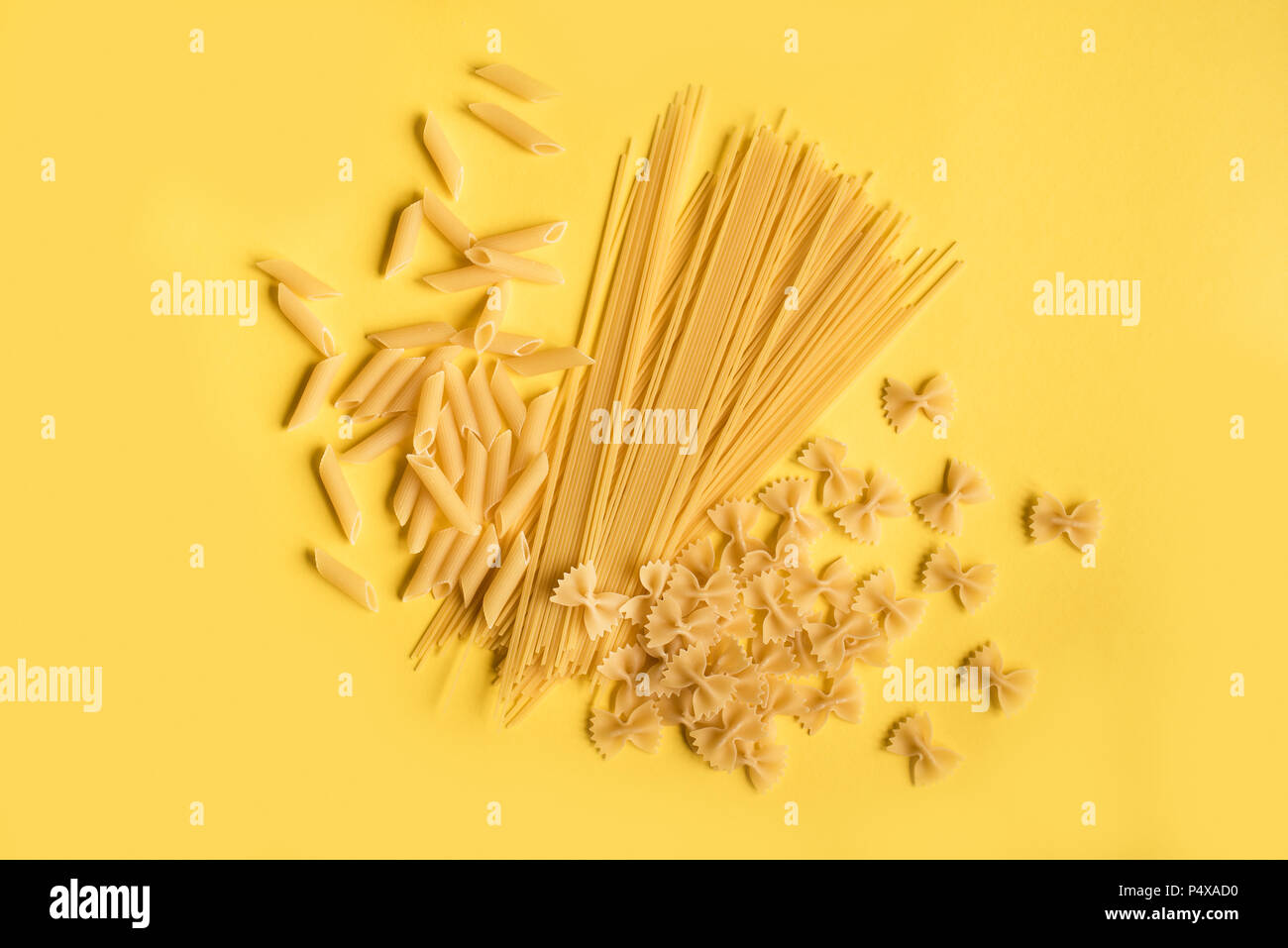 Assorted various uncooked raw pasta on yellow background. Italian pasta ...