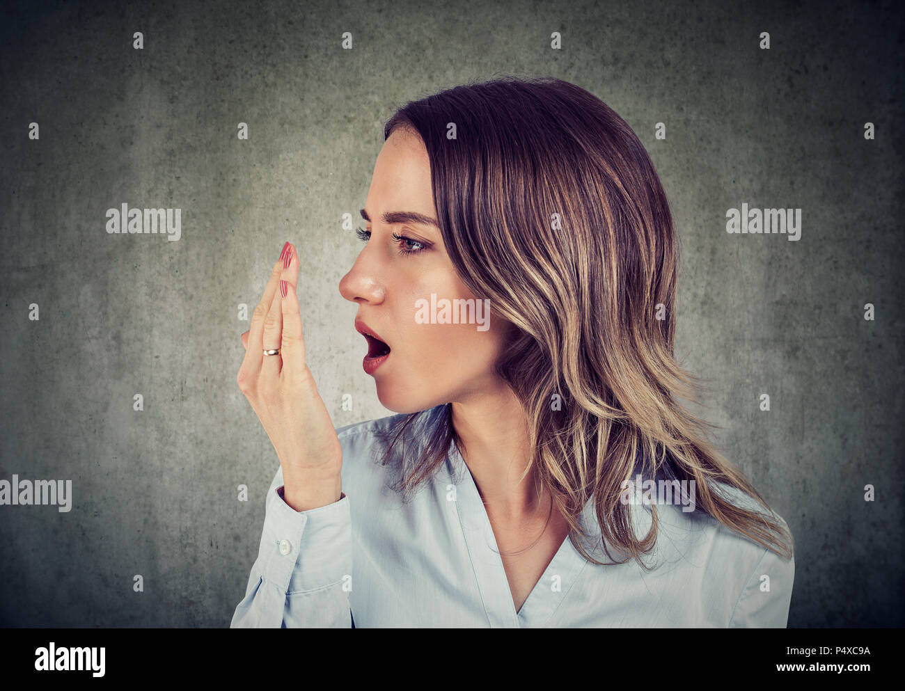 Woman doing a hand breath test Stock Photo - Alamy