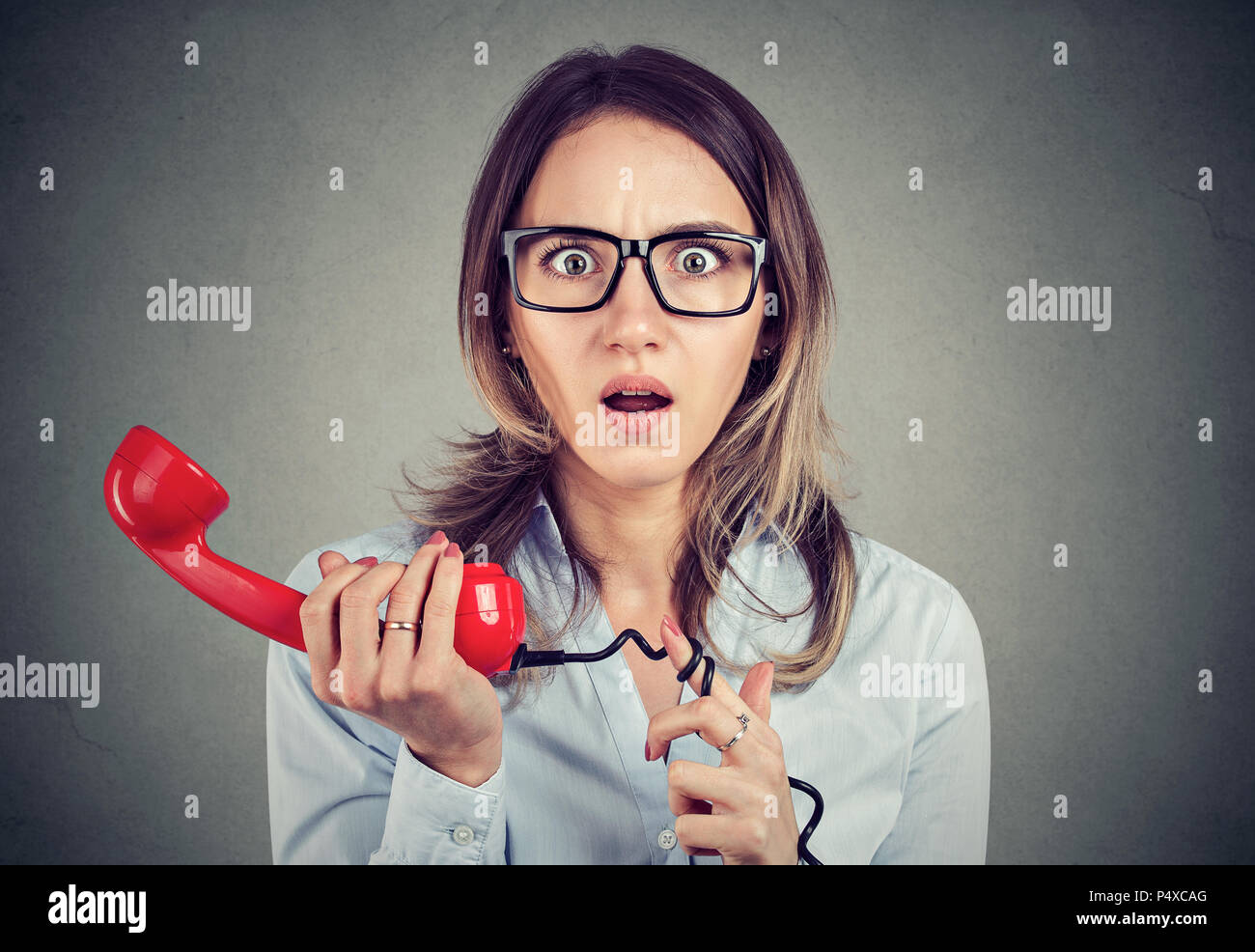 Shocked young business woman receiving bad news over the telephone ...