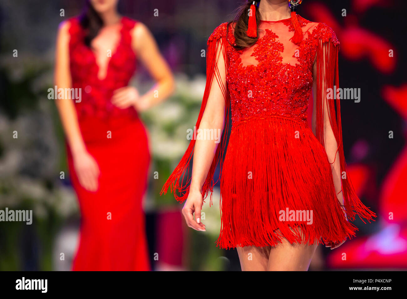 Female models walk the runway in red dresses during a Fashion Show ...
