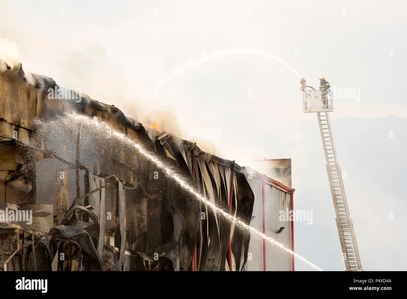 Fire disaster in a warehouse. Fire fighting in an industrial area Stock ...