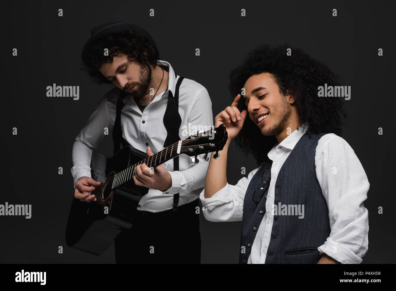 duet of musicians playing guitar and singing on black Stock Photo - Alamy
