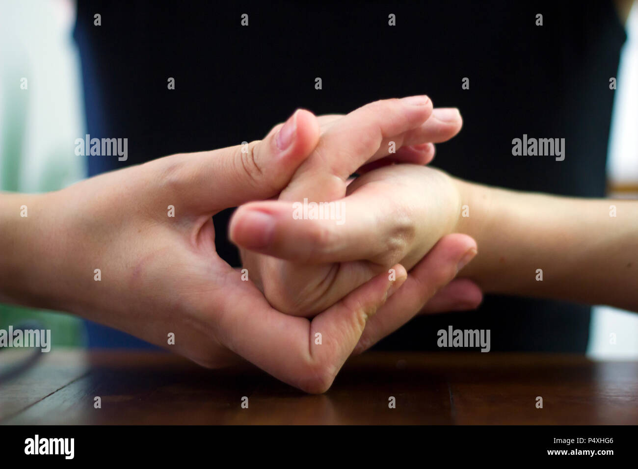 Woman cracking their knuckles Stock Photo - Alamy
