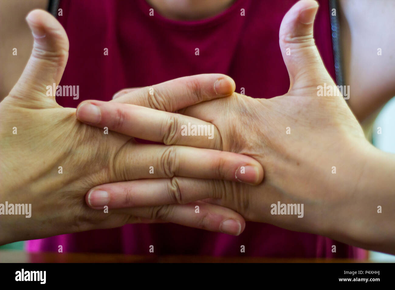 Older woman cracking their knuckles Stock Photo - Alamy