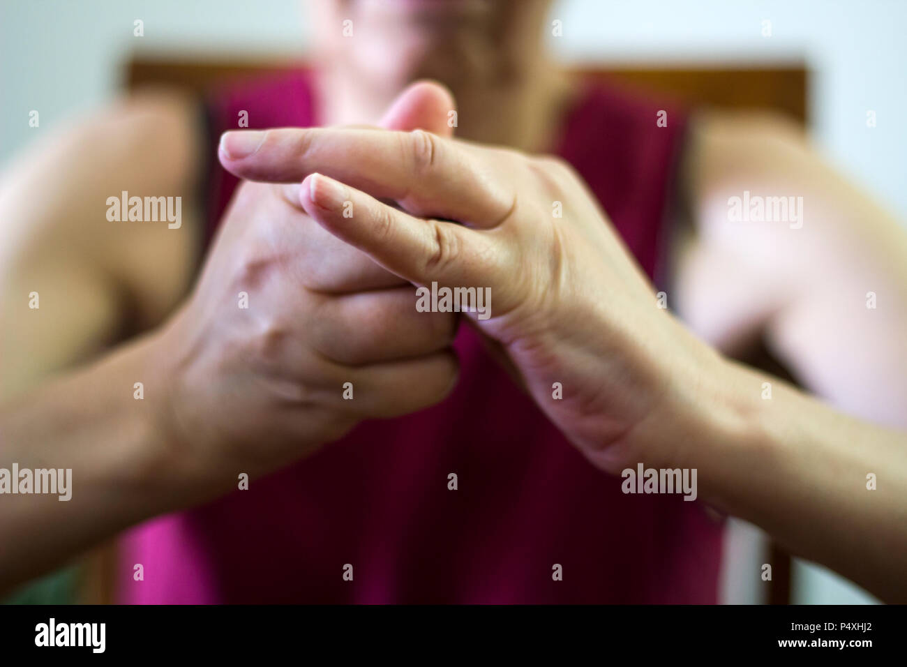 Older woman cracking their knuckles Stock Photo - Alamy