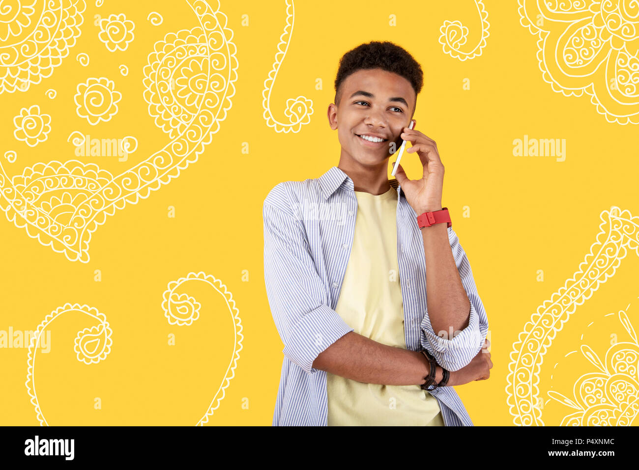 Young person smiling and talking on the phone Stock Photo - Alamy