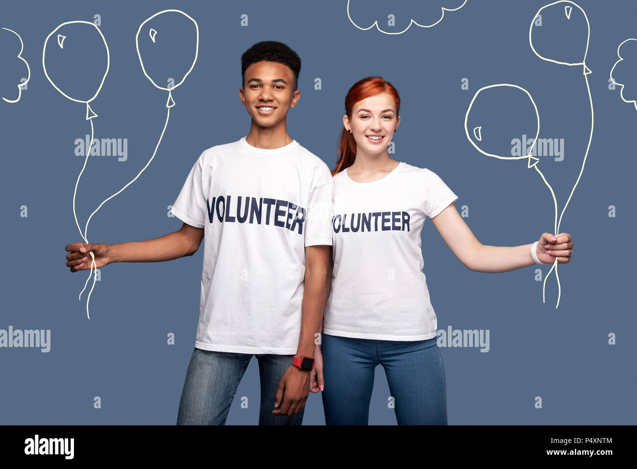 Positive volunteers holding balloons while playing with children Stock ...