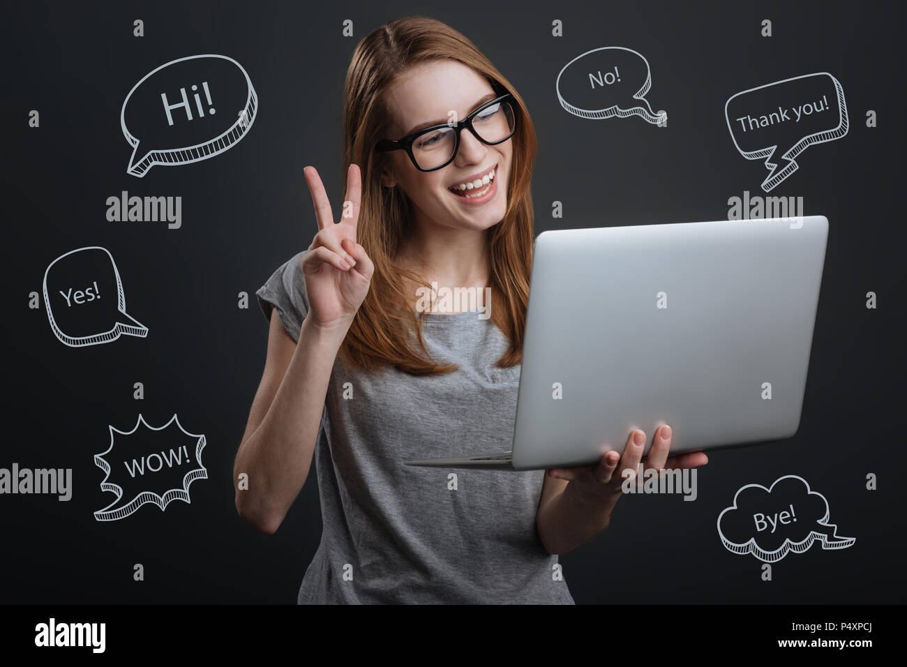 Cheerful student smiling when having a video call Stock Photo - Alamy