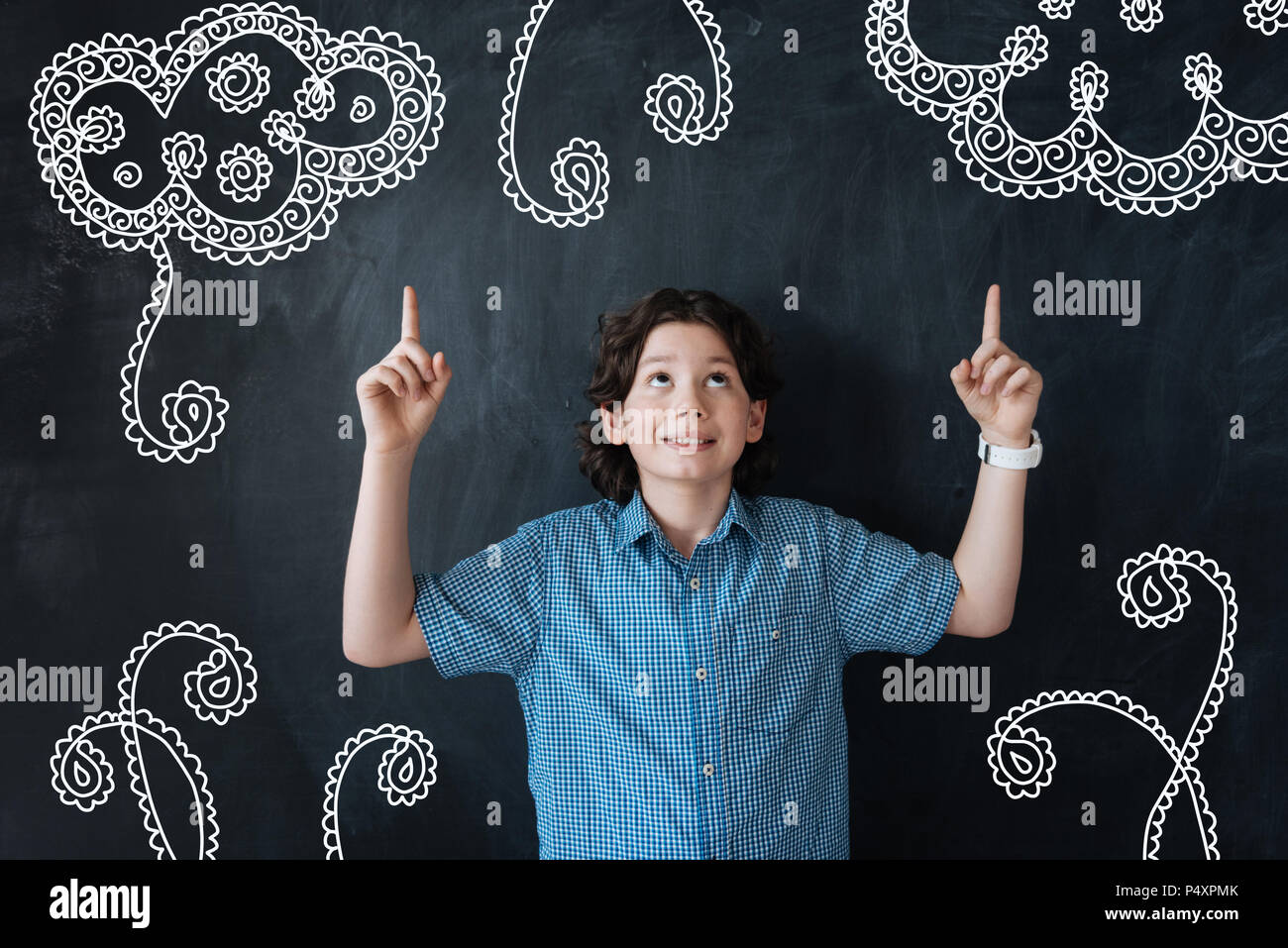 Clever boy looking up and pointing his fingers up Stock Photo - Alamy