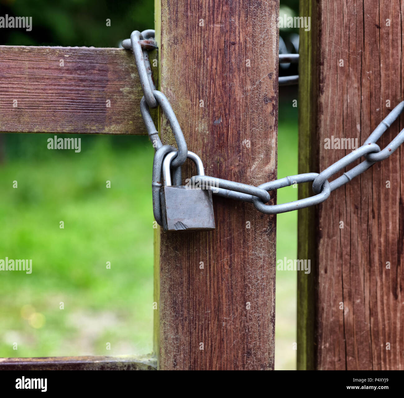 Key lock and thick chain on fence post Stock Photo - Alamy