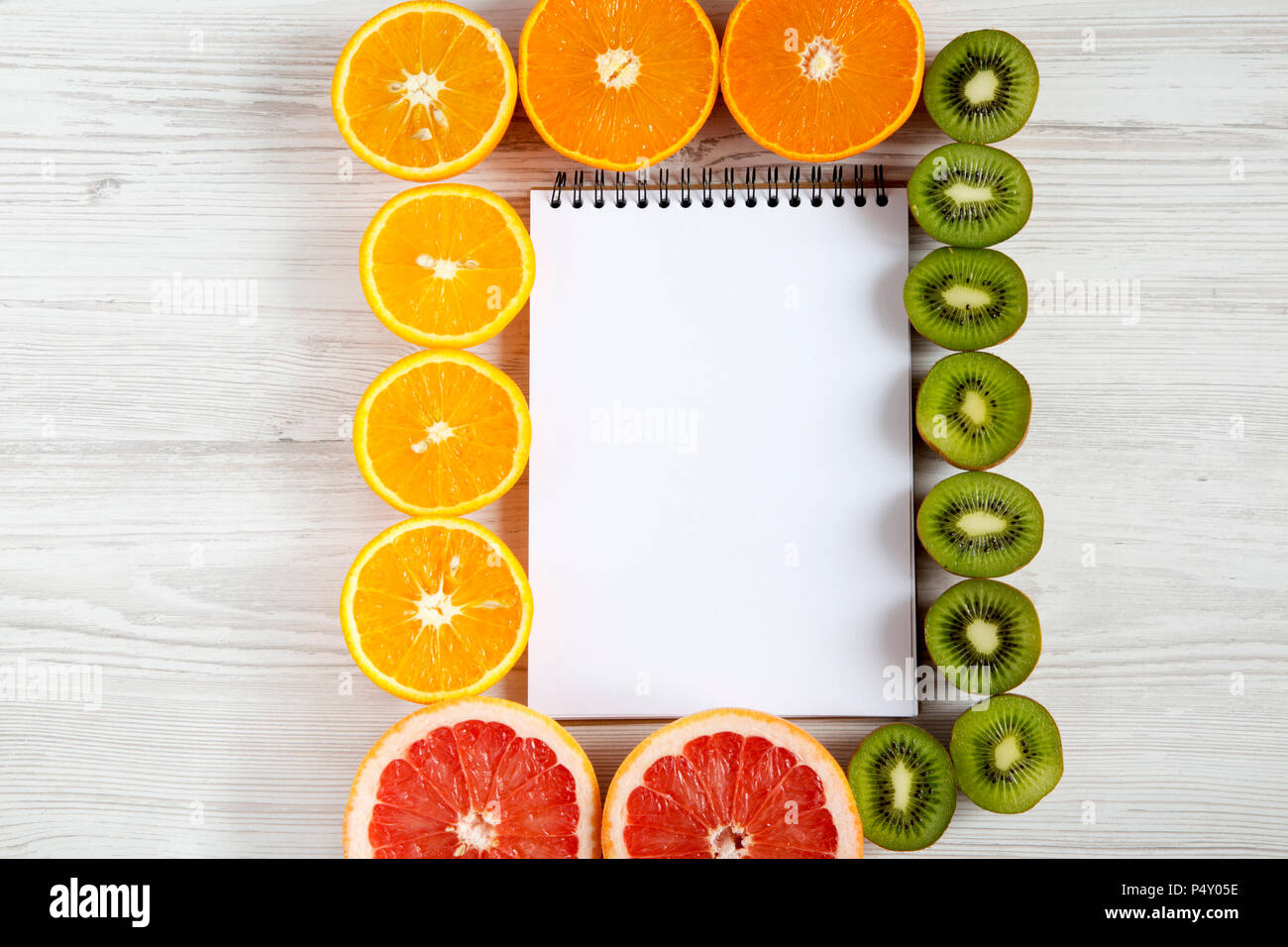 Top view Flat lay notebook with sliced kiwi, orange, grapefruit and ...