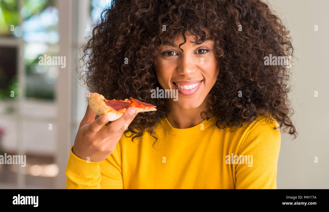 African american woman ready to eat pepperoni pizza slice with a happy ...