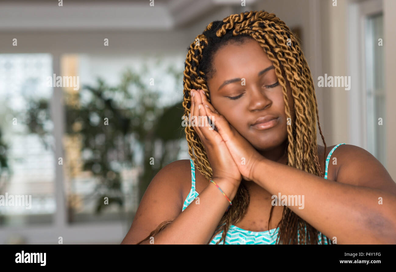 African american woman at home sleeping tired dreaming and posing with ...