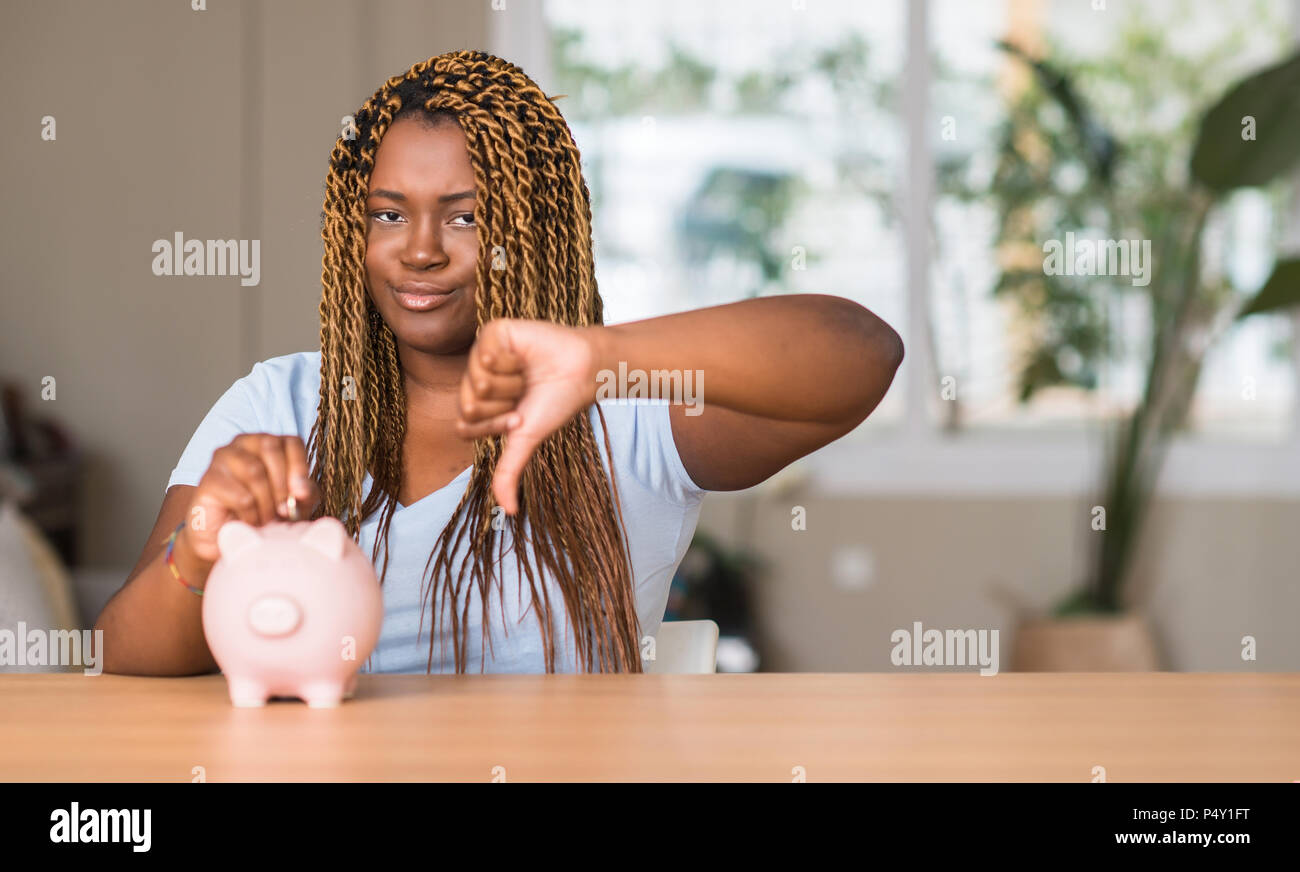 African american woman saving money with piggy bank with angry face ...
