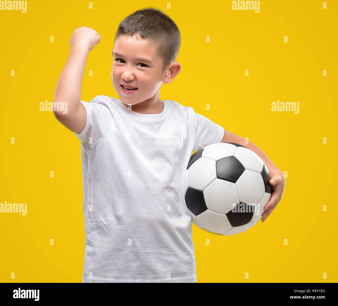 Dark haired little child playing with soccer ball annoyed and ...