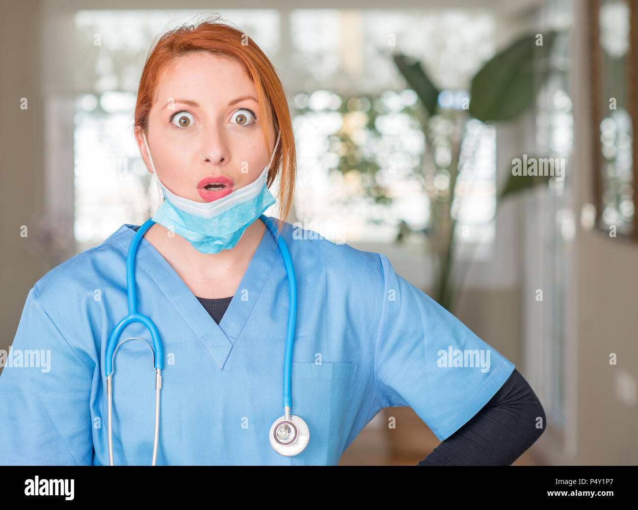 Medical professional woman with stethoscope scared in shock with a ...