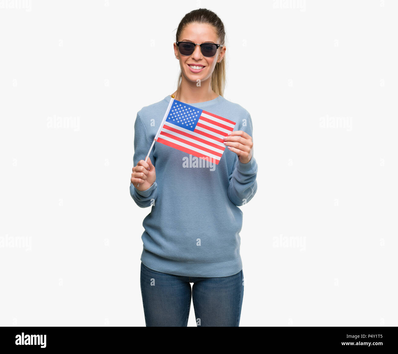 Beautiful young woman holding USA flag with a happy face standing and ...
