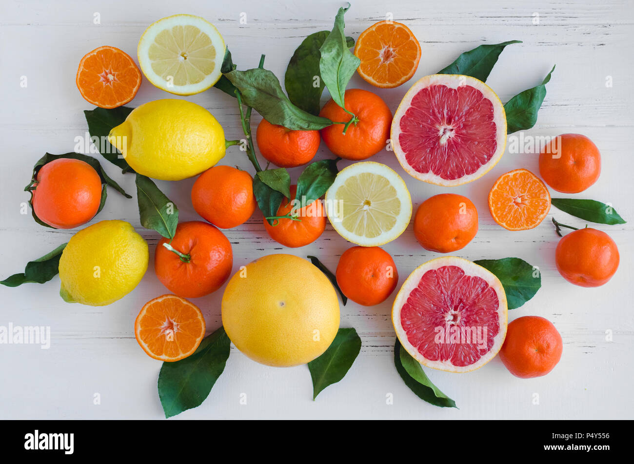 Mixed citrus background. Assorted fresh citrus fruits with leaves on ...
