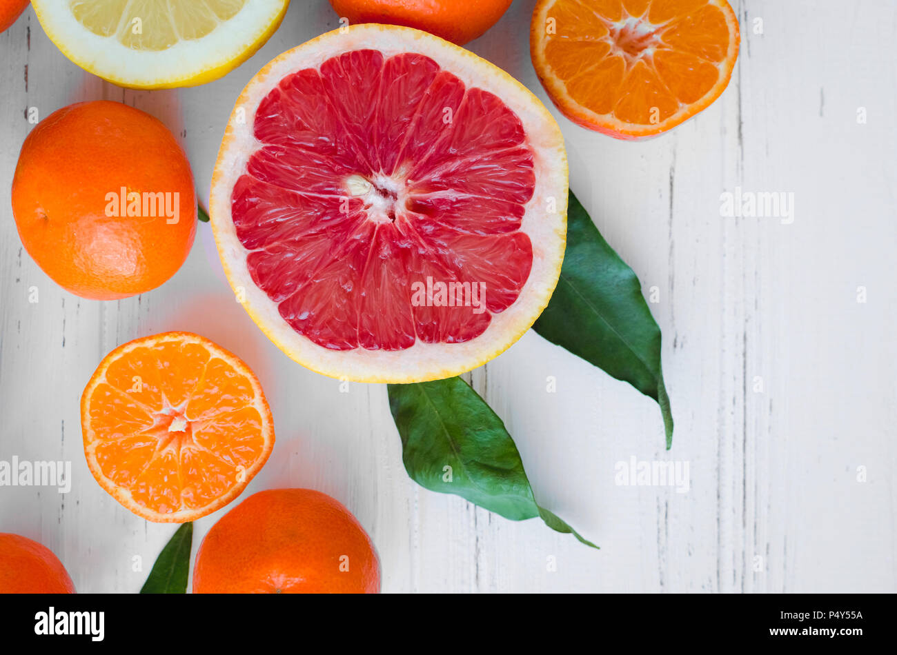 Mixed citrus background. Assorted fresh citrus fruits with leaves on ...