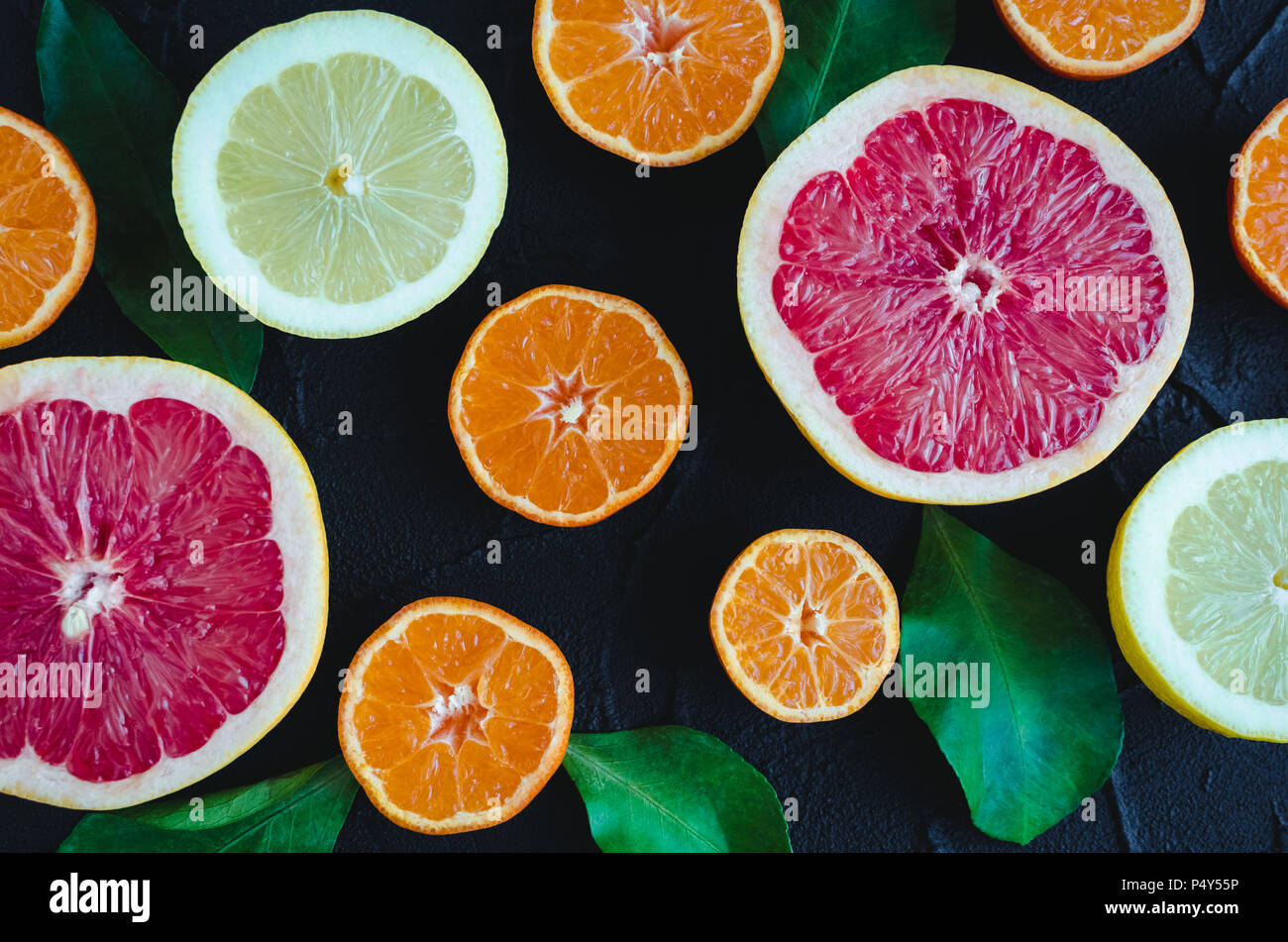 Mixed citrus background. Assorted fresh citrus fruits with leaves on ...