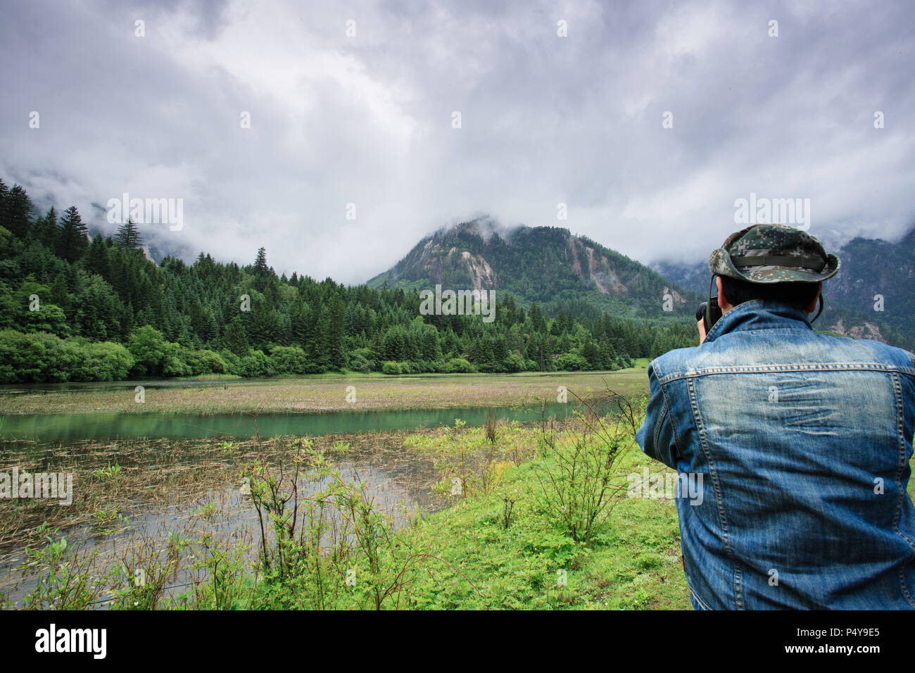 A man holds a camera to record plateau scenery Stock Photo - Alamy