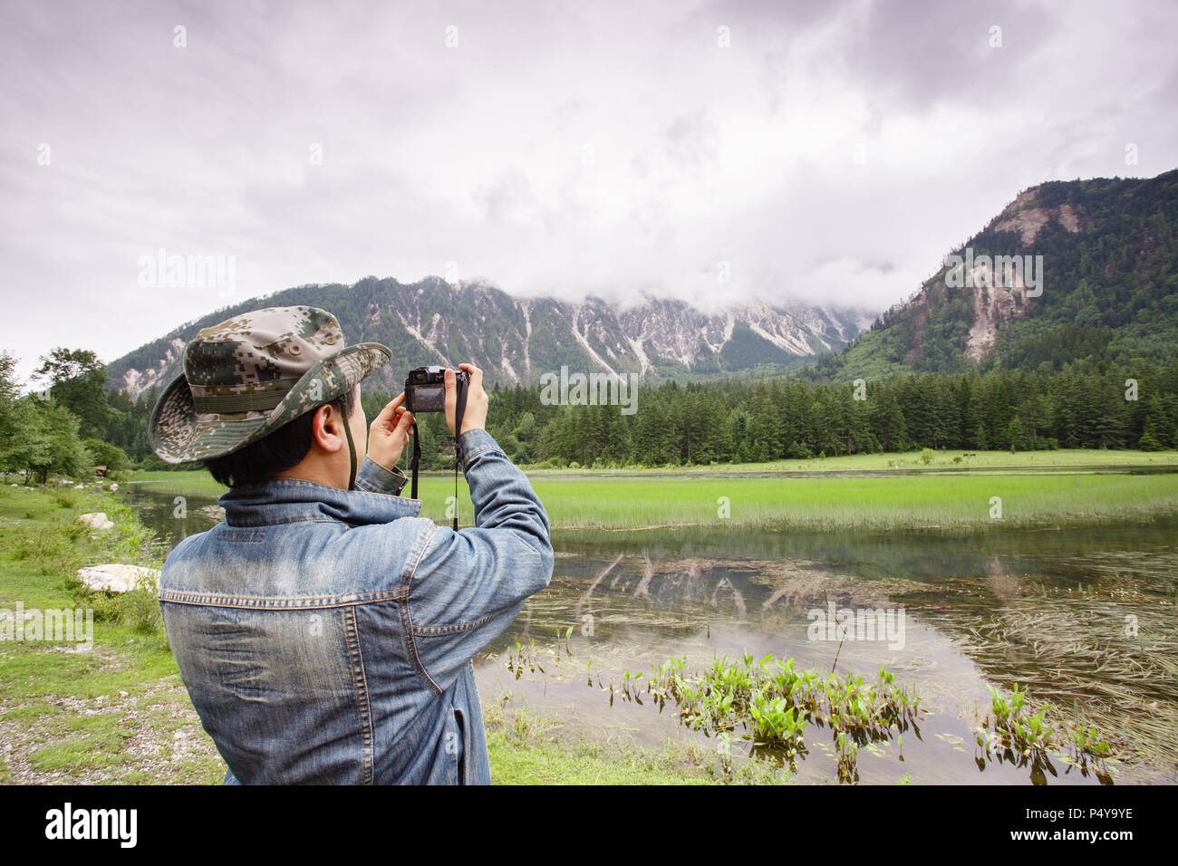 A man holds a camera to record plateau scenery Stock Photo - Alamy