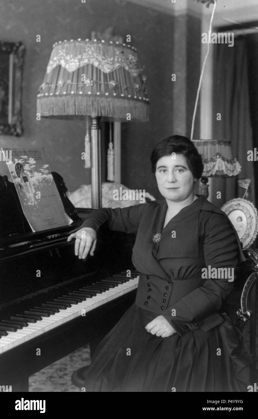 Amy Castles, three-quarters length portrait, seated at piano, facing ...