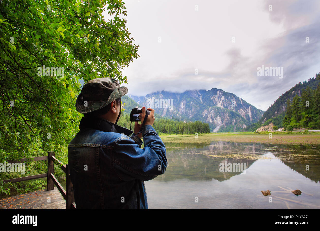 A man holds a camera to record plateau scenery Stock Photo - Alamy