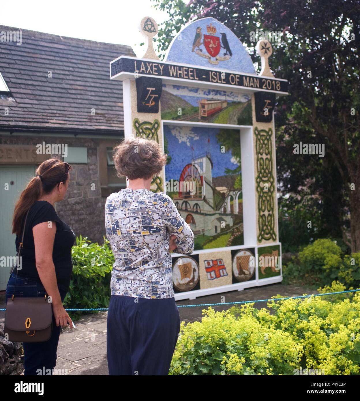 Tideswell. Derbyshire. 23rd June 2018 Two women admire the decoration ...