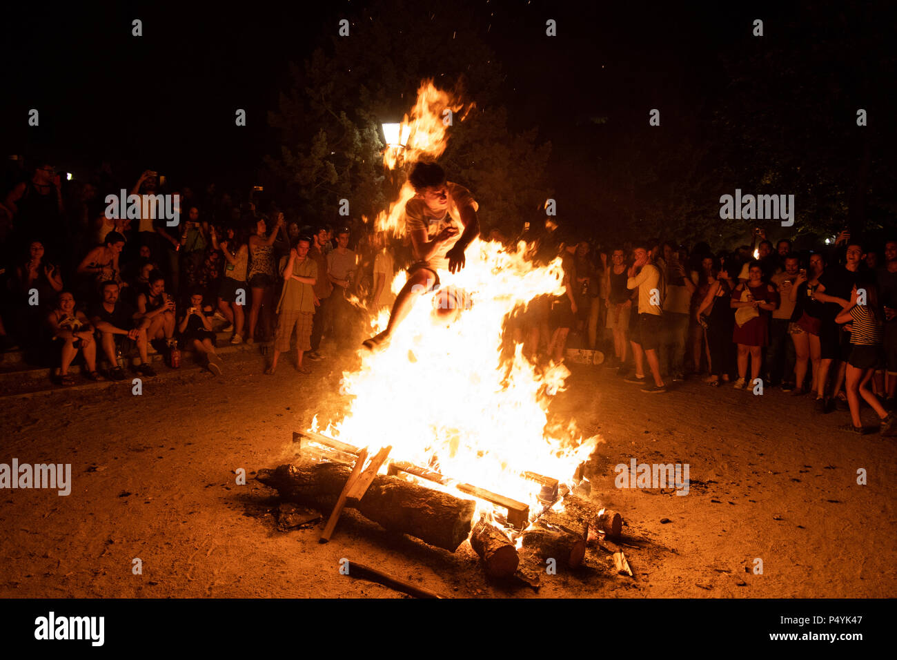 Madrid, Spain. 23rd June, 2018. A man jumping through the fire of a ...
