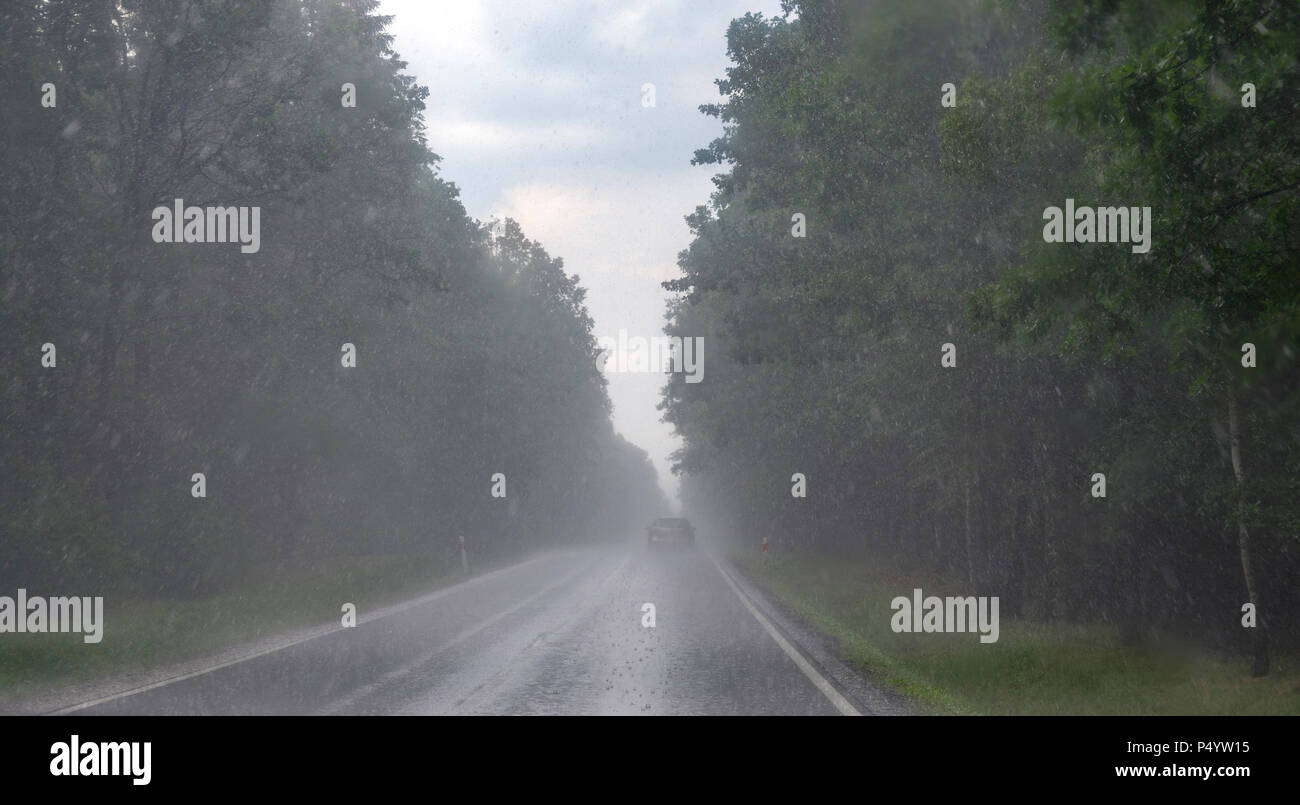 Asphalt road during very heavy rain. View through front windscreen of ...