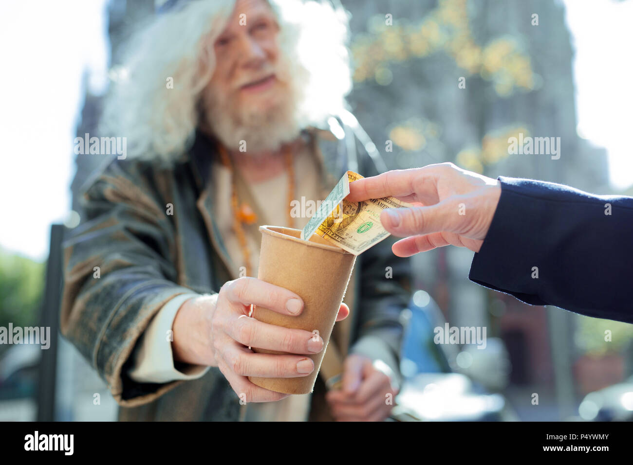 Kind-hearted man helping homeless outside Stock Photo - Alamy