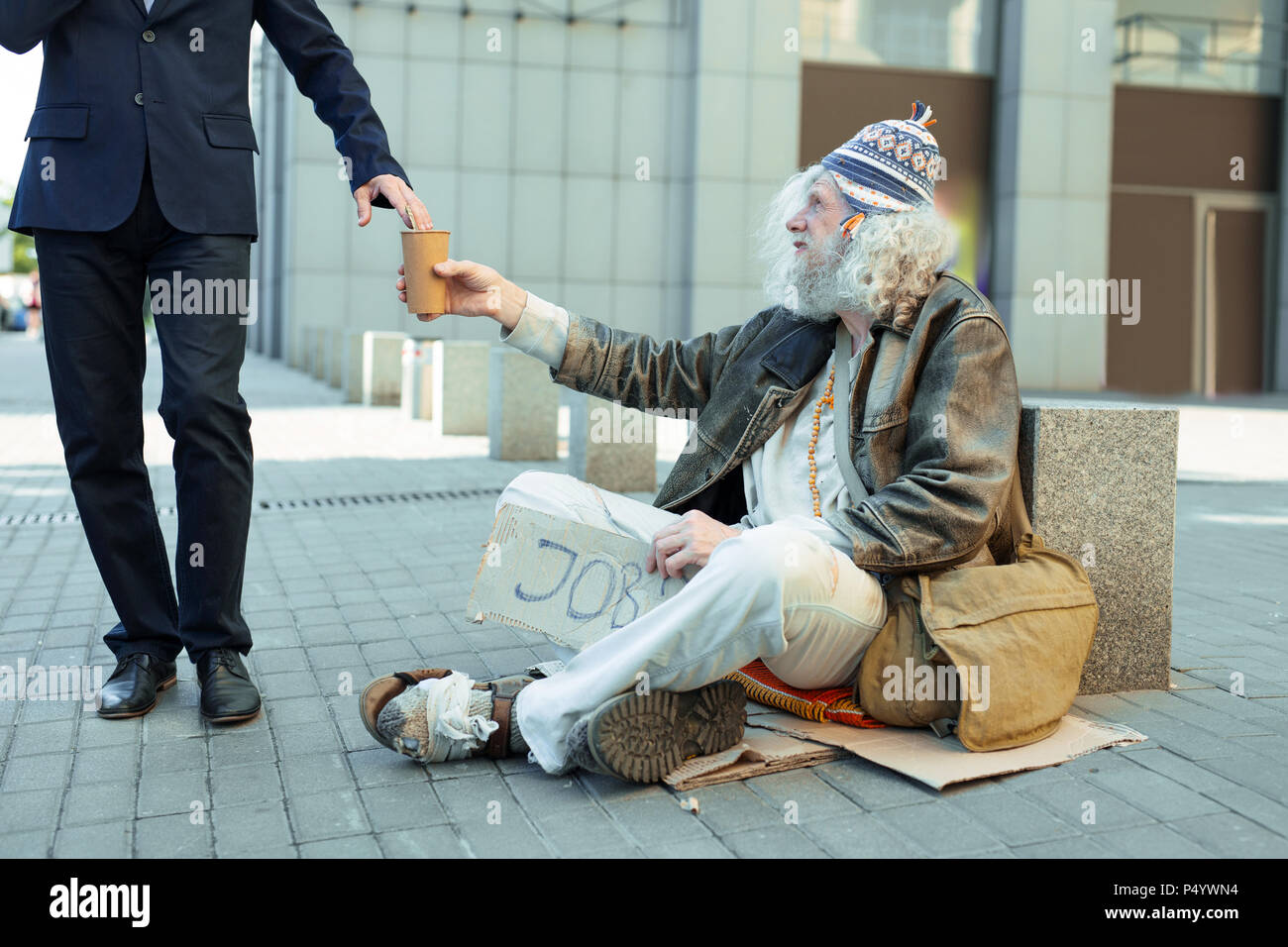 Street person sitting on the street begging for help Stock Photo - Alamy