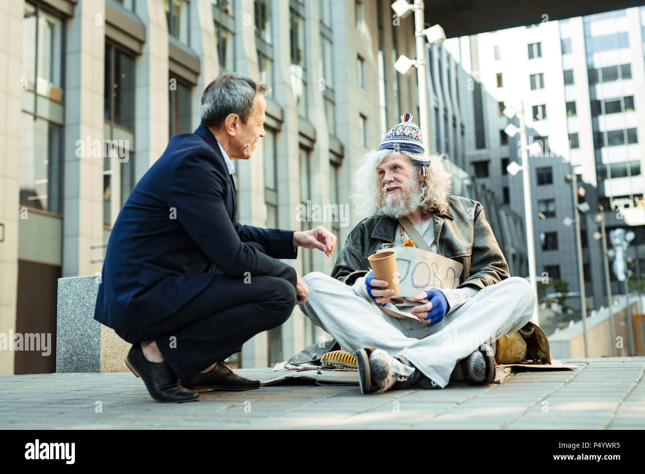 Charity man asking street person about his feelings Stock Photo - Alamy