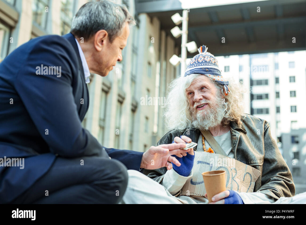 Supportive stranger giving homeless money for food Stock Photo - Alamy