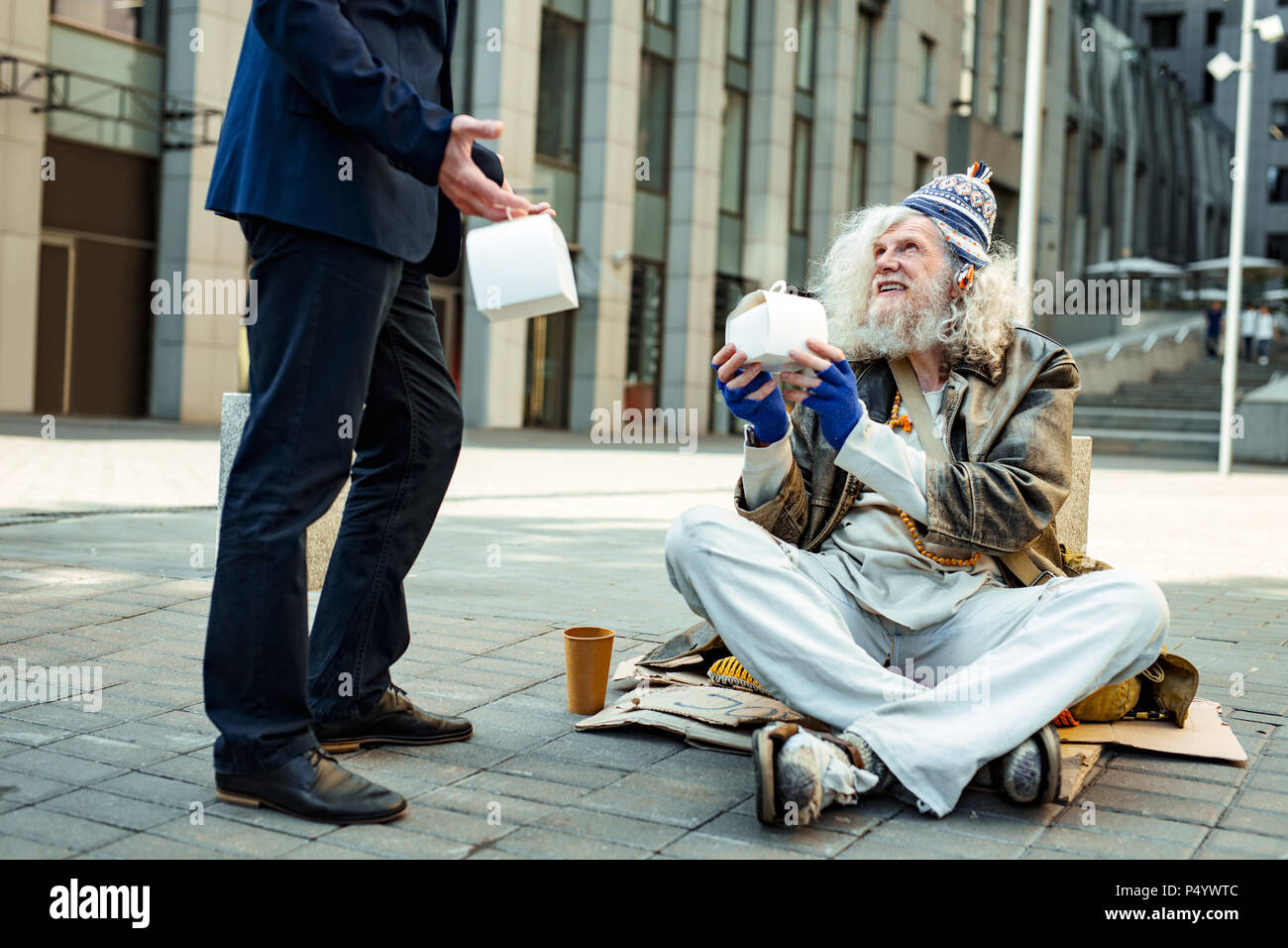 Kind-hearted businessman helping homeless on his way home Stock Photo ...