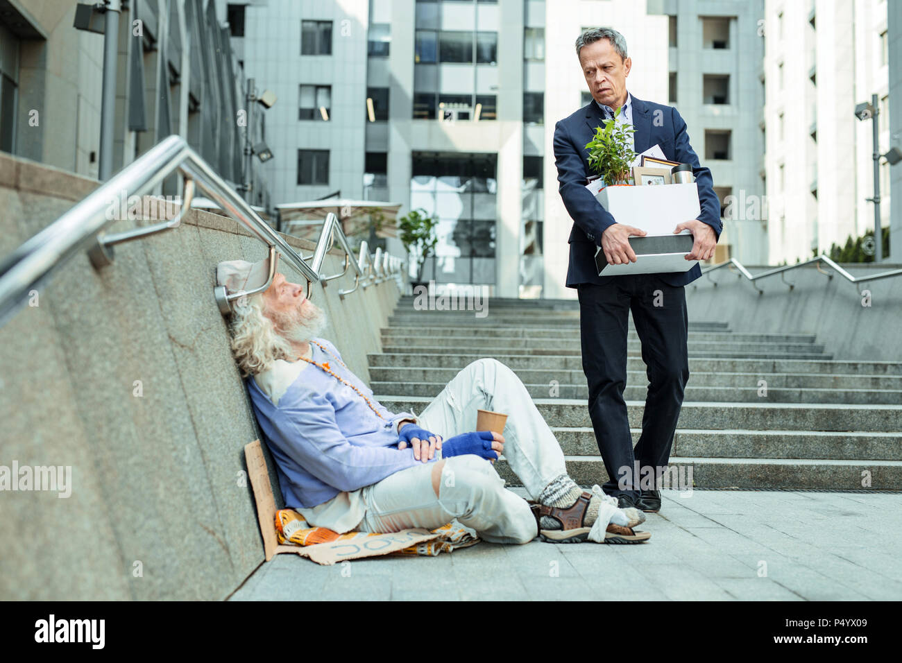 Poor starving man sitting on the floor outside the office Stock Photo ...
