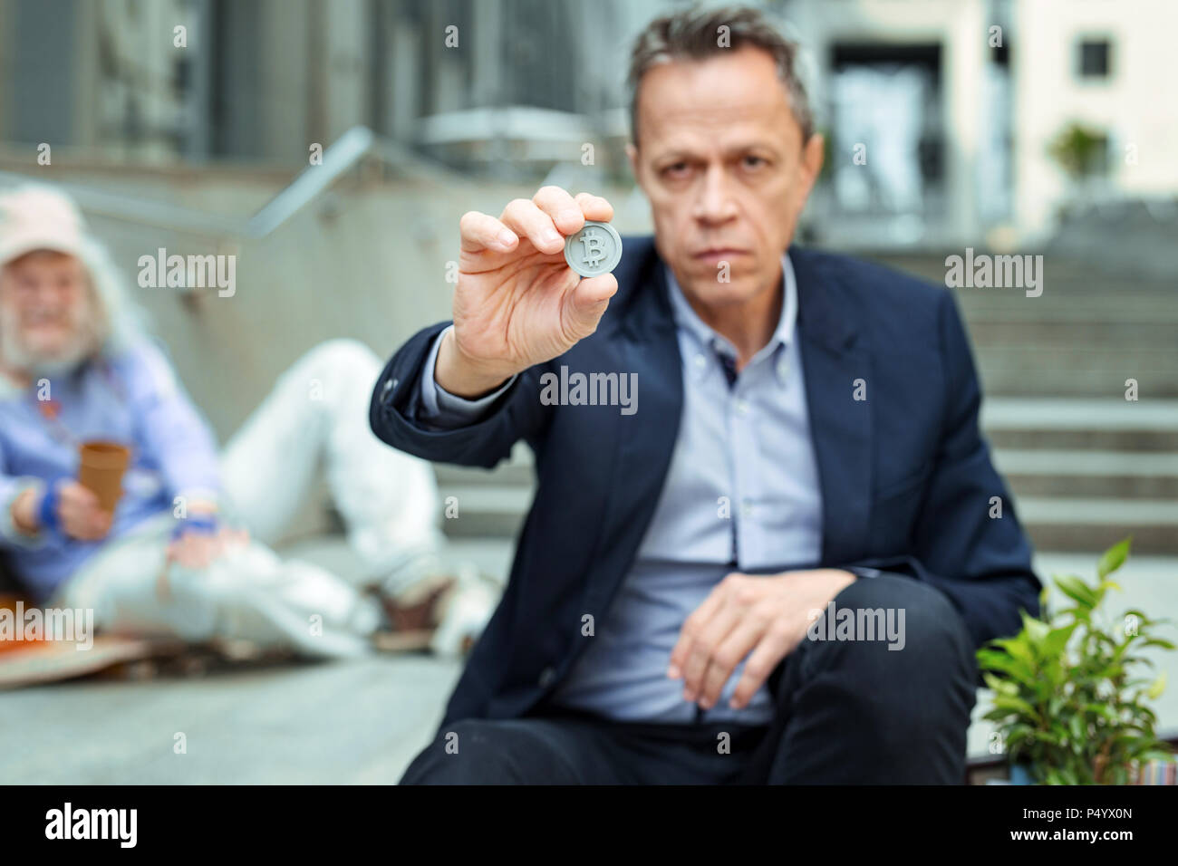 Businessman holding underground token in his hand Stock Photo - Alamy