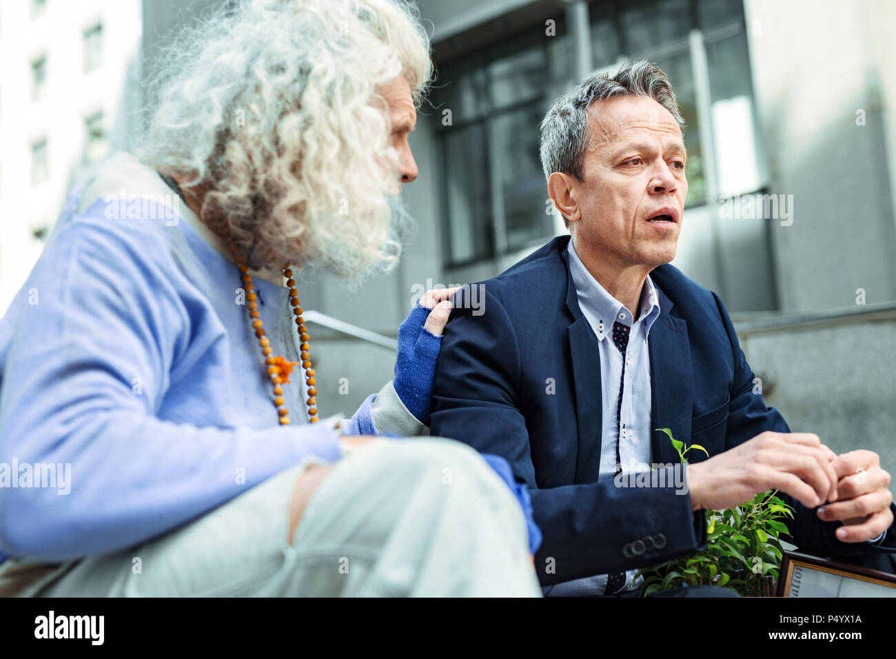 Kind-hearted hippy man calming emotional stranger Stock Photo - Alamy